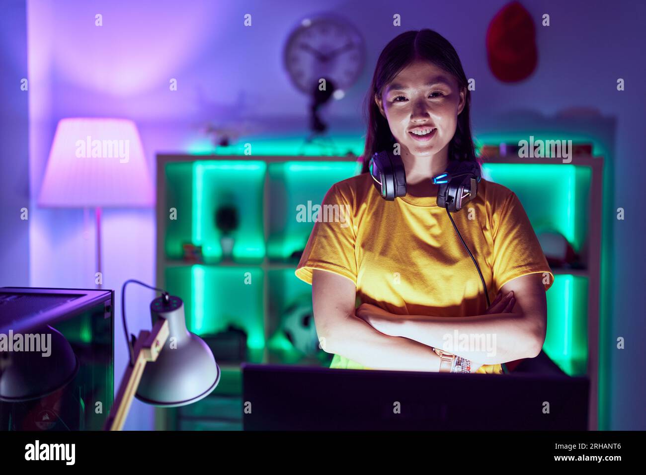 Chinese woman streamer wearing headset standing with arms crossed ...