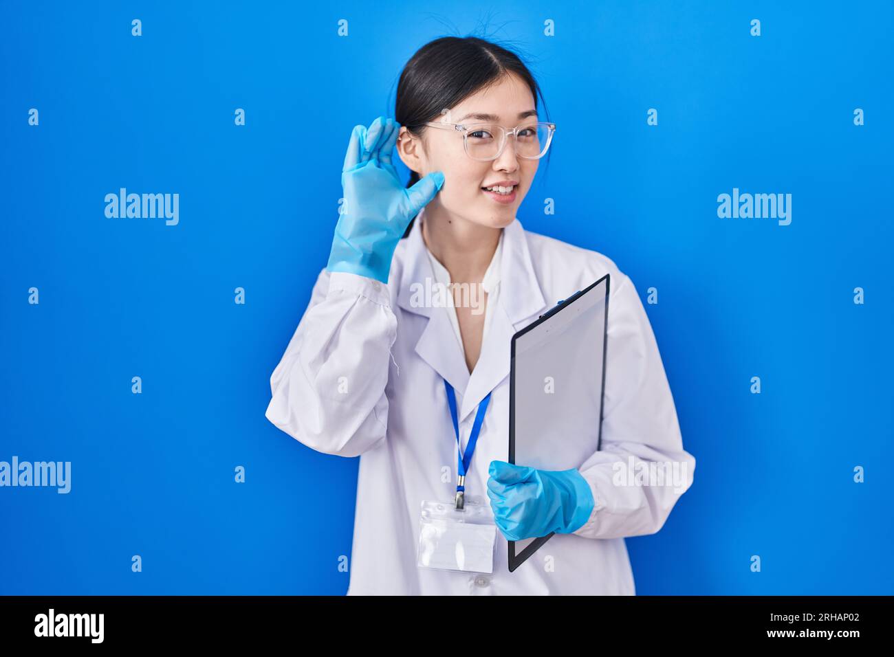 Chinese young woman working at scientist laboratory smiling with hand ...