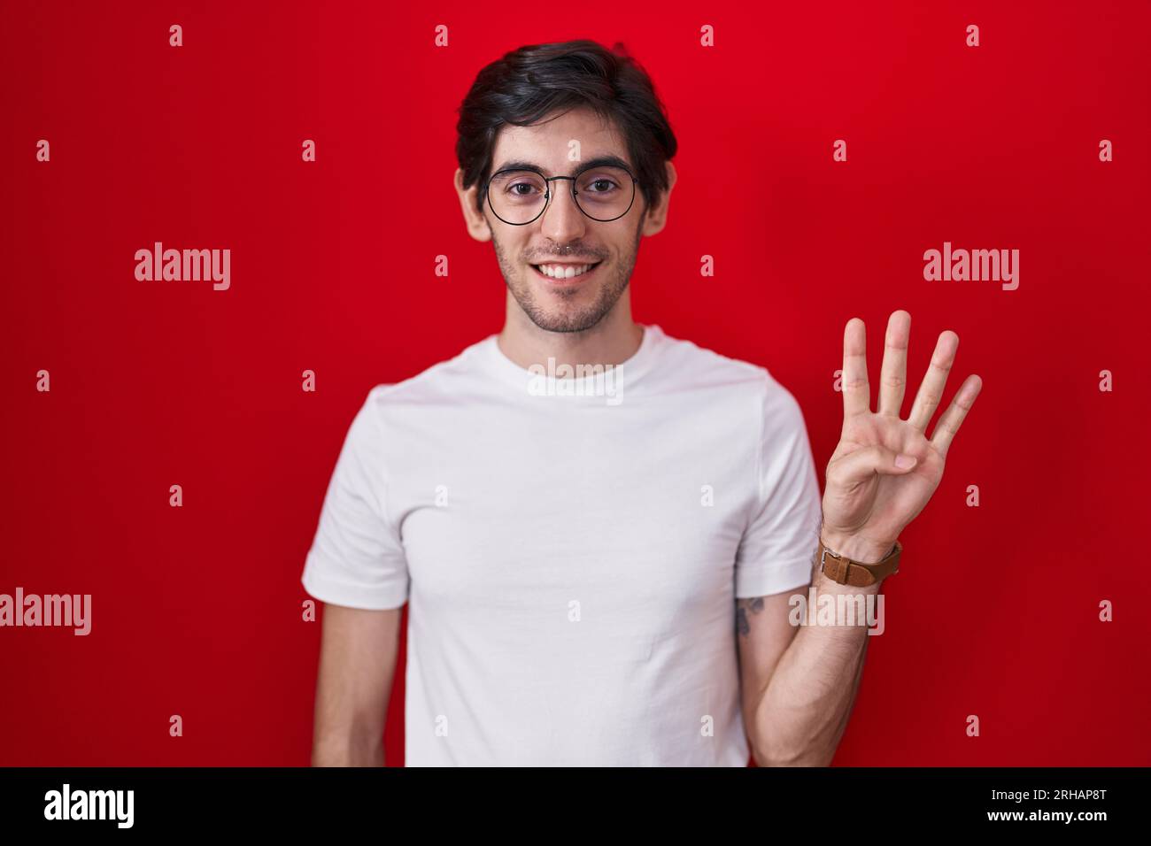 Young hispanic man standing over red background showing and pointing up ...