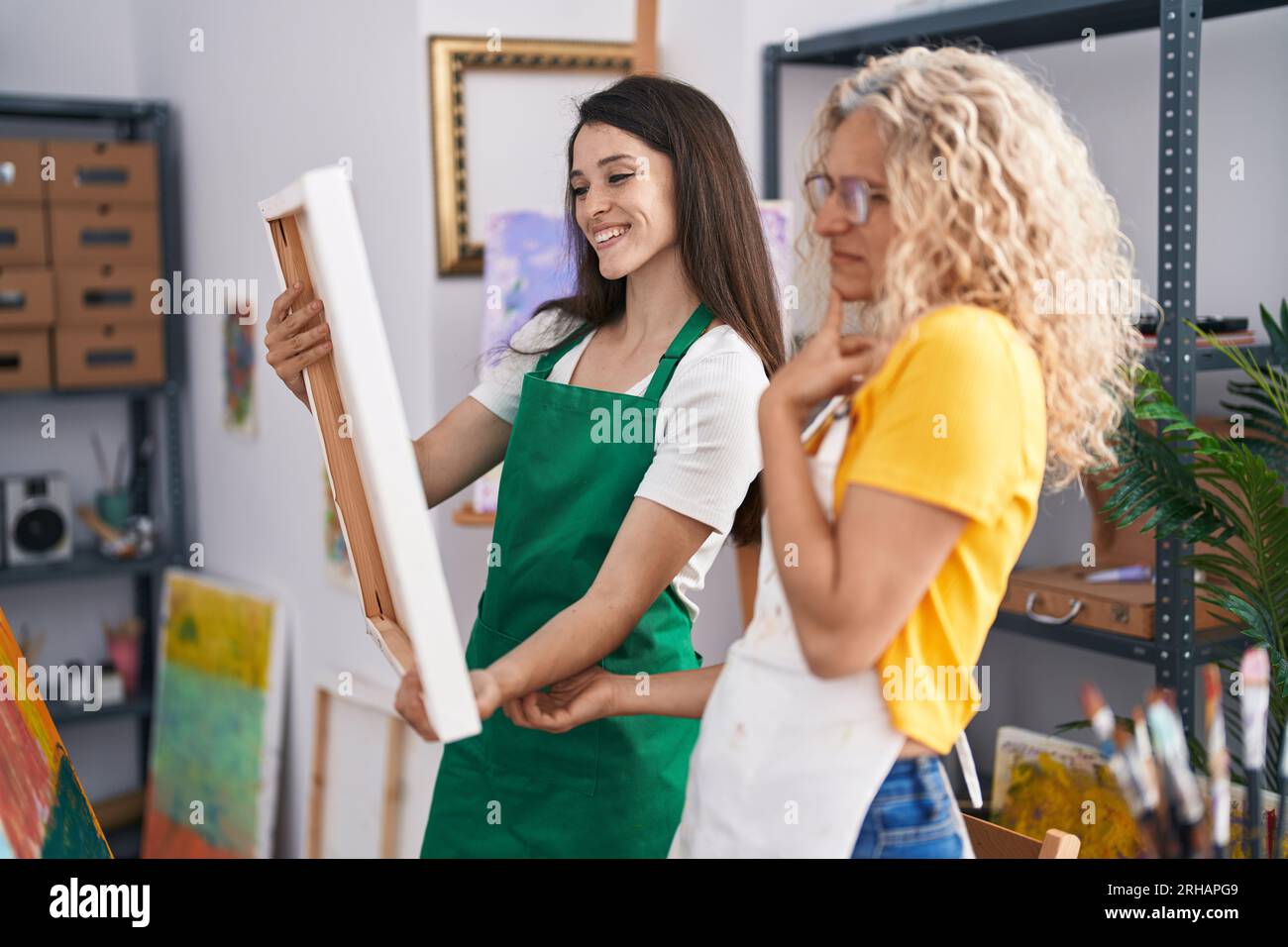 Two women artists smiling confident holding draw at art studio Stock ...