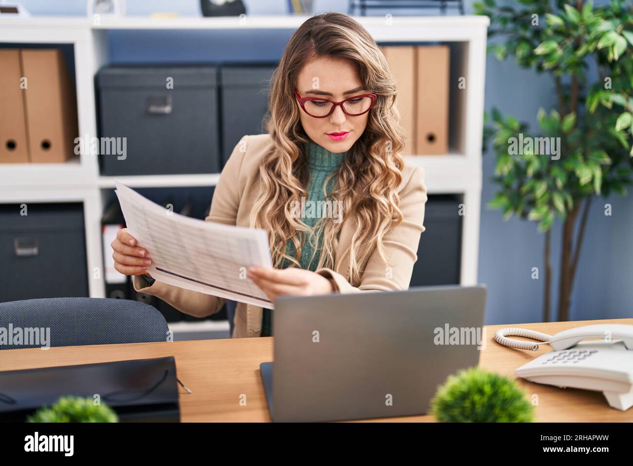 Young woman business worker reading document working at office Stock ...