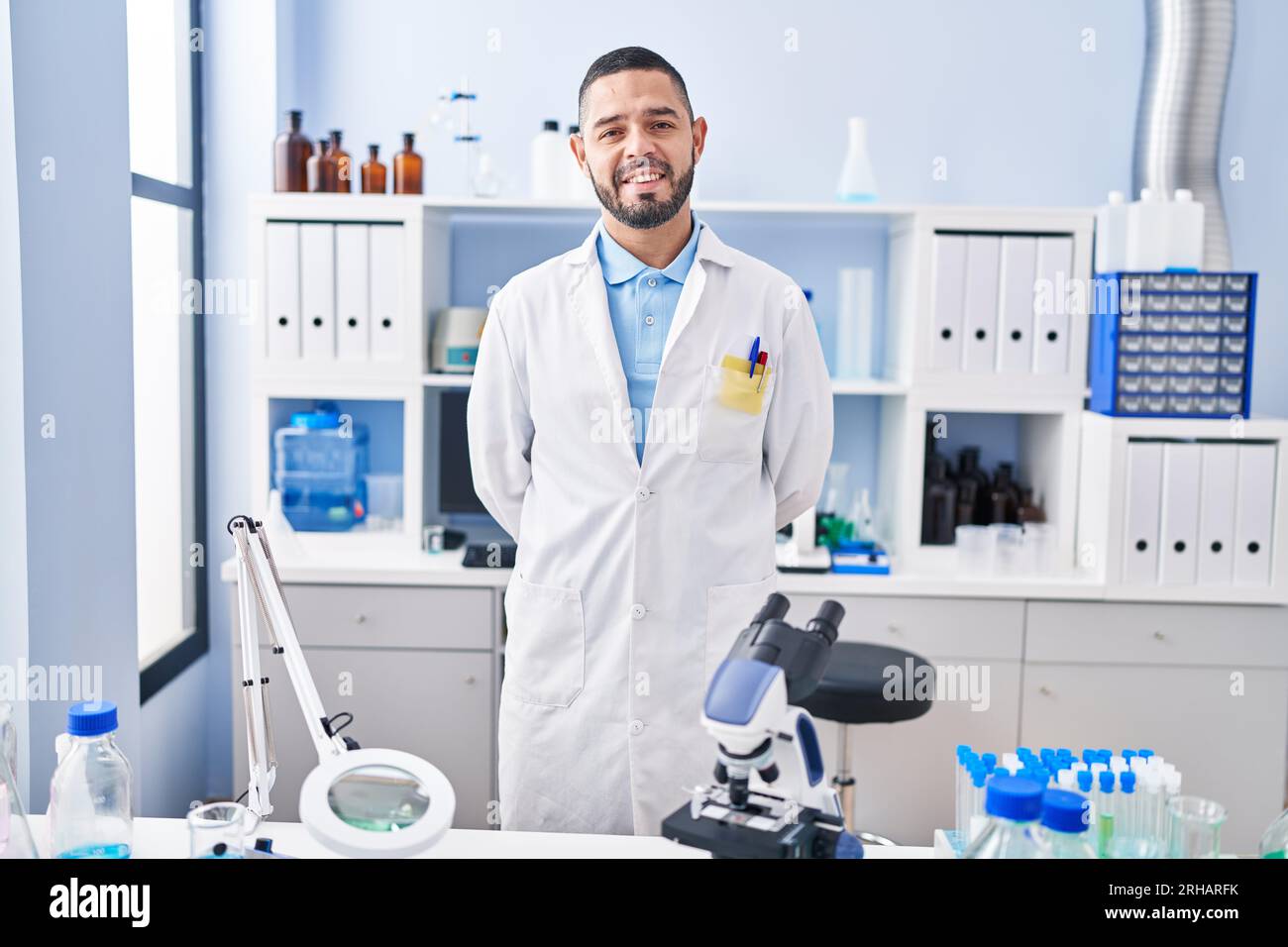 Young latin man scientist smiling confident standing at laboratory Stock Photo - Alamy