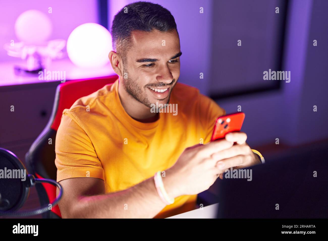Young hispanic man streamer using computer and smartphone at gaming ...