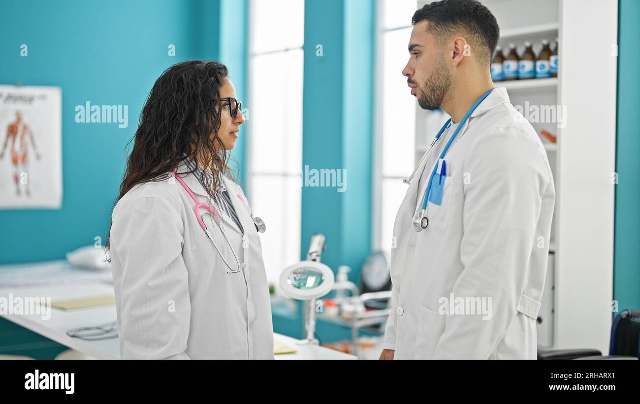 Man and woman doctors standing together speaking at the clinic Stock Photo - Alamy
