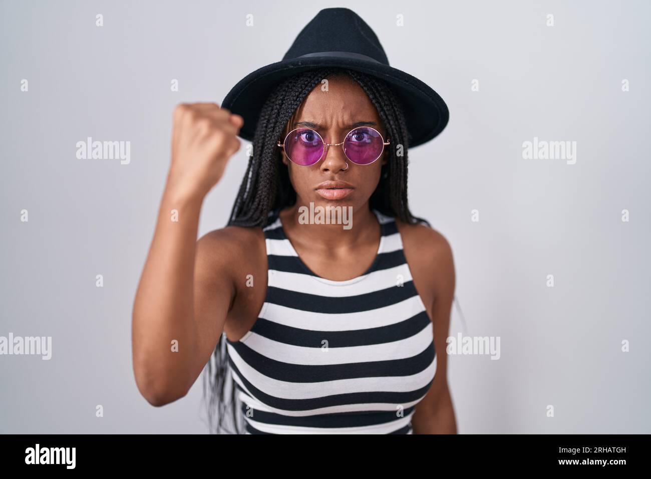 Young african american with braids wearing hat and sunglasses angry and ...