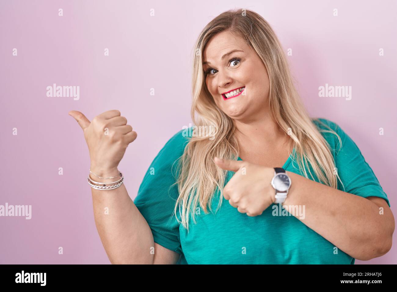 Caucasian plus size woman standing over pink background pointing to the ...