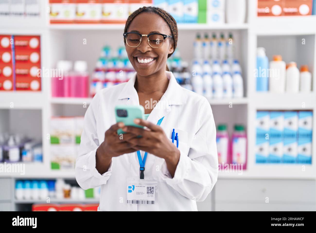 African american woman pharmacist using smartphone working at pharmacy ...