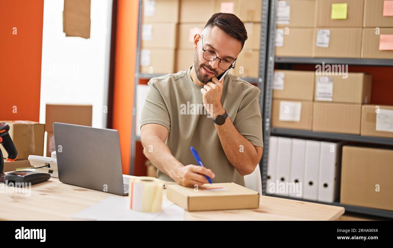 Young hispanic man ecommerce business worker talking on smartphone ...