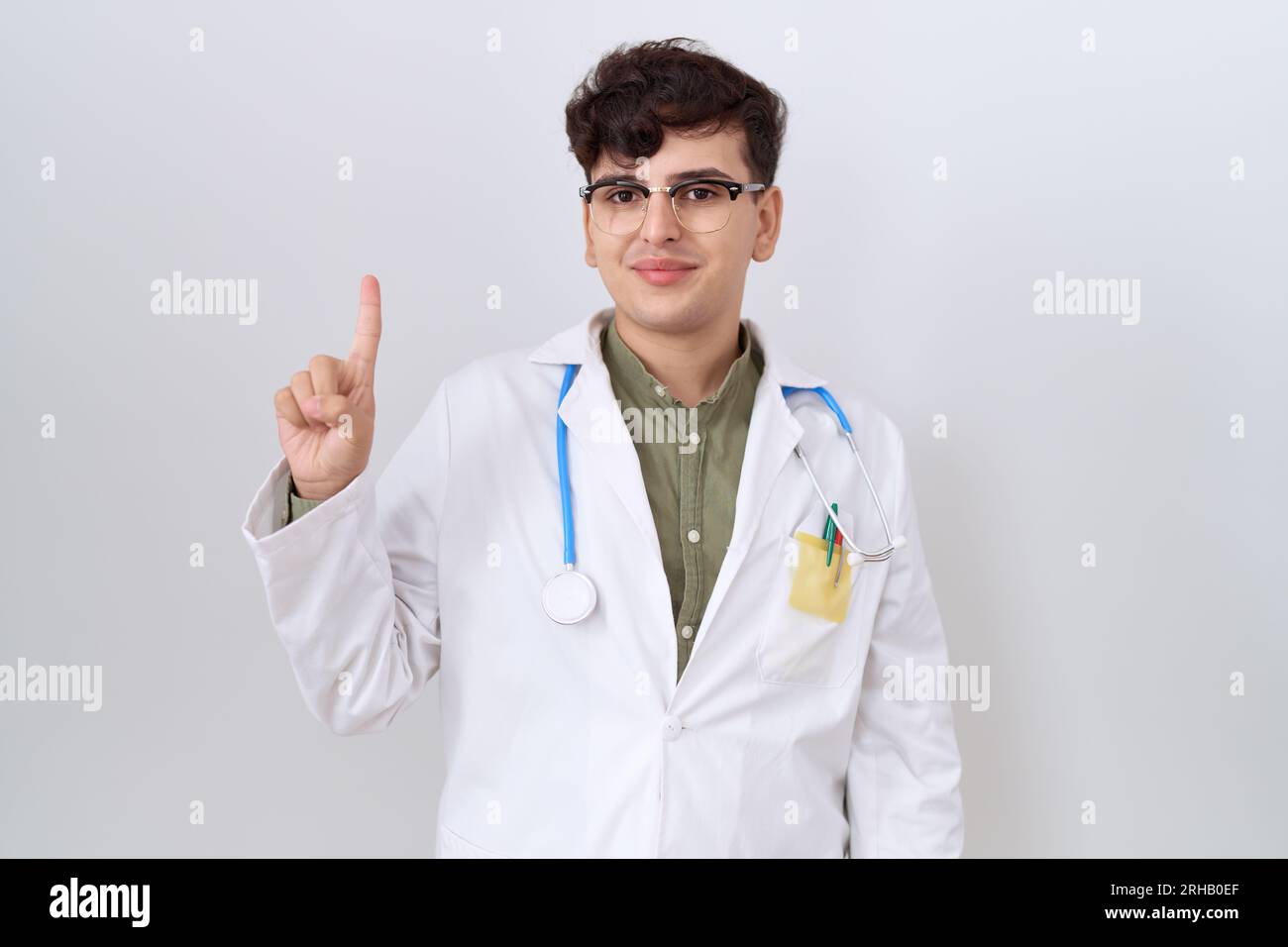 Young non binary man wearing doctor uniform and stethoscope showing and ...