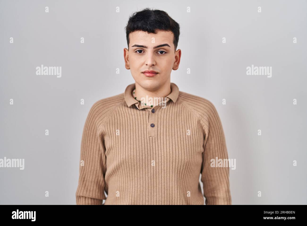 Non binary person standing over isolated background relaxed with ...