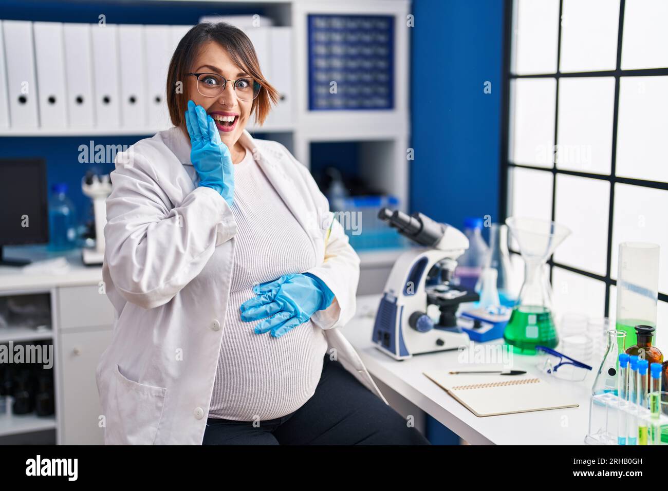 Pregnant woman working at scientist laboratory afraid and shocked ...