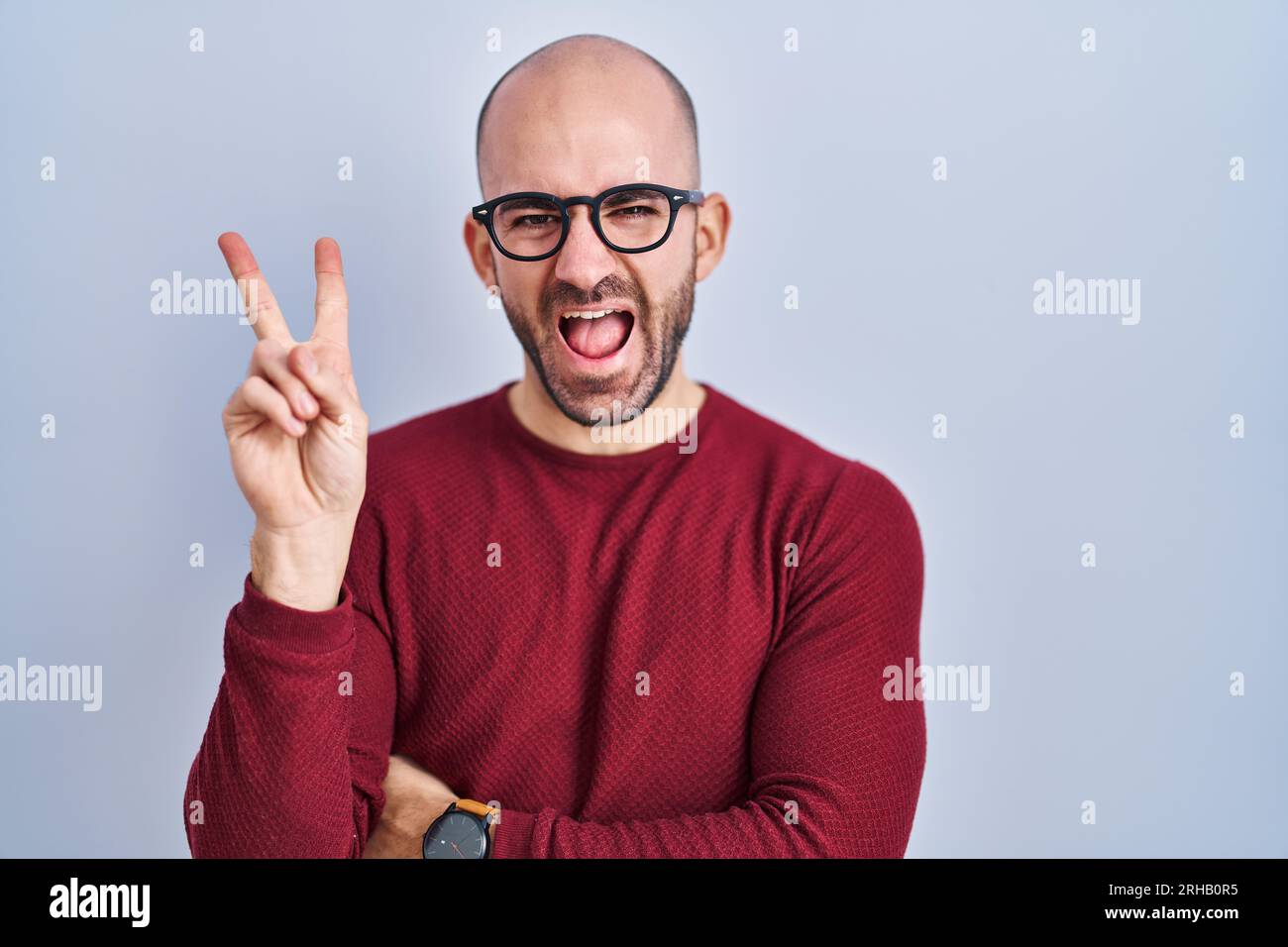 Young bald man with beard standing over white background wearing ...