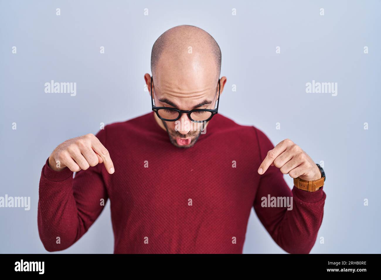 Young bald man with beard standing over white background wearing ...
