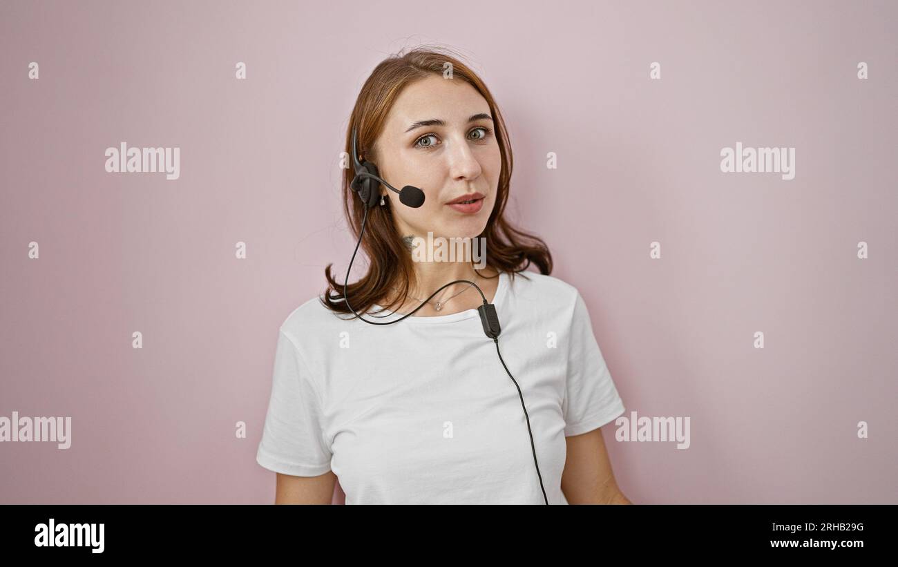 Young woman call center agent speaking over isolated pink background ...