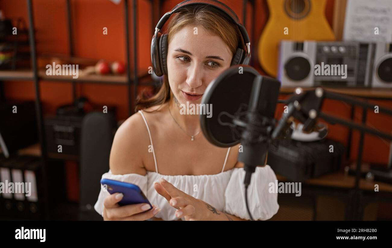 Young woman radio reporter working reading smartphone message speaking ...