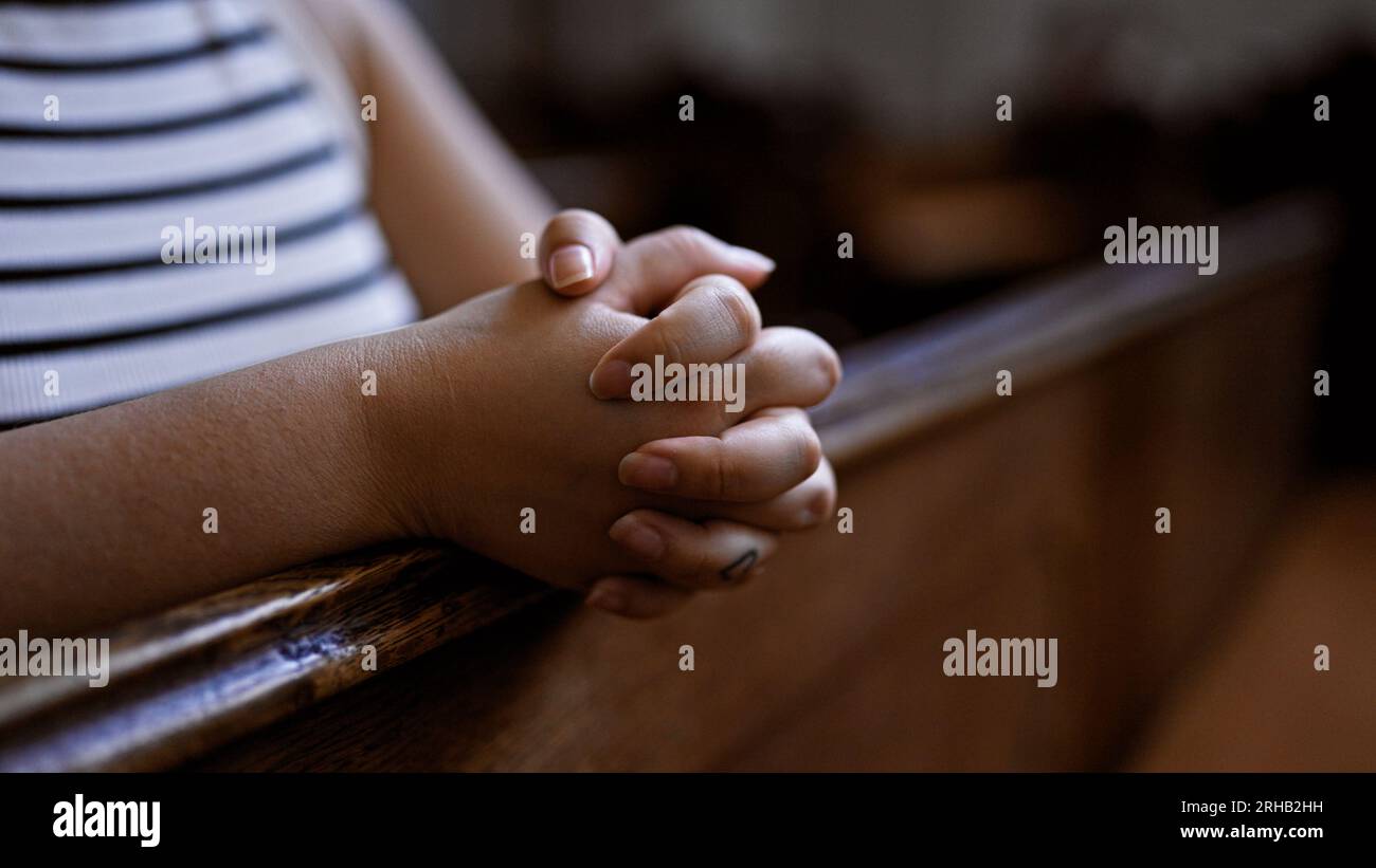 Young beautiful hispanic woman praying on a church bench at Augustinian ...