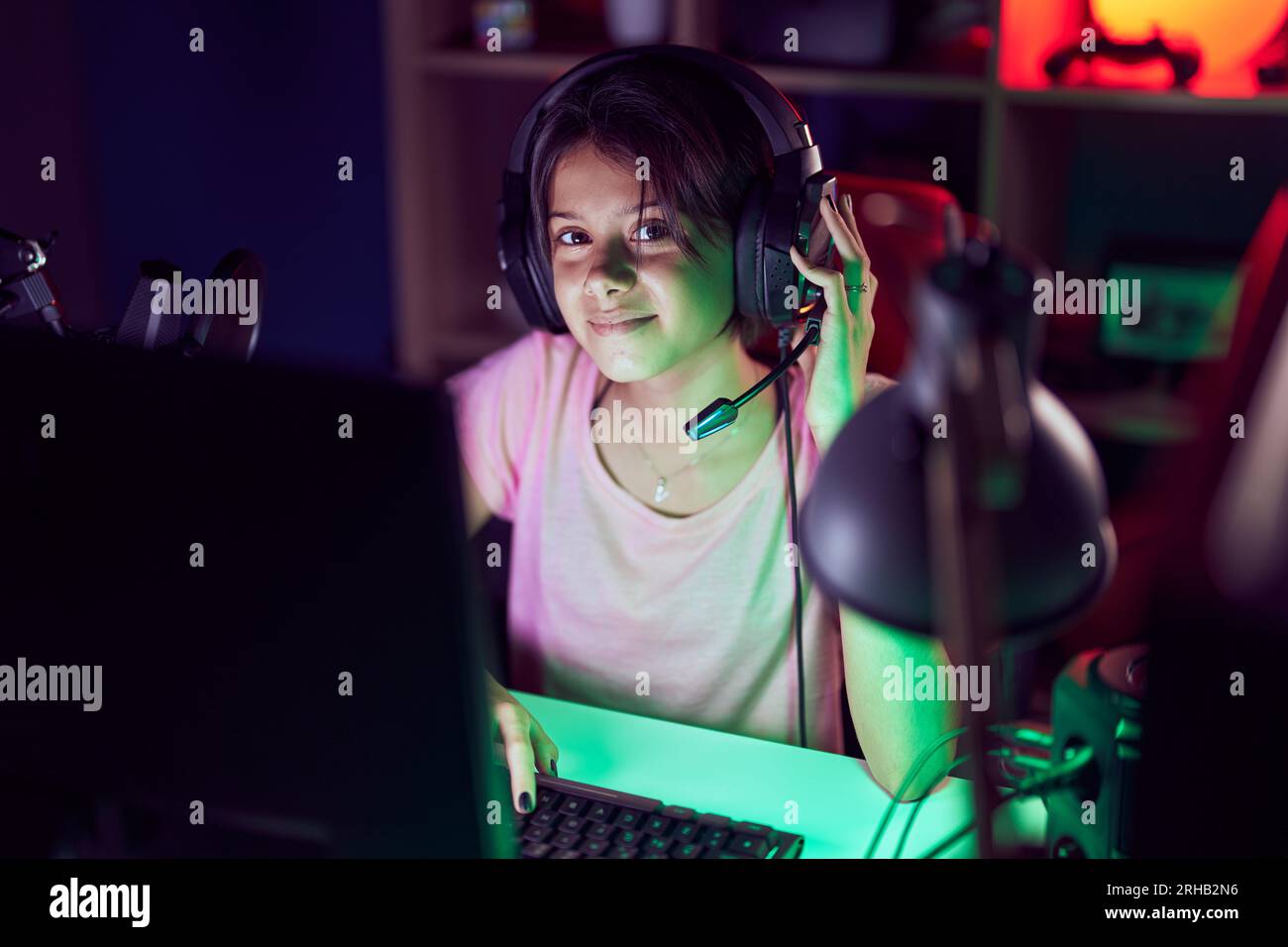 Adorable hispanic girl streamer playing video game using computer at ...
