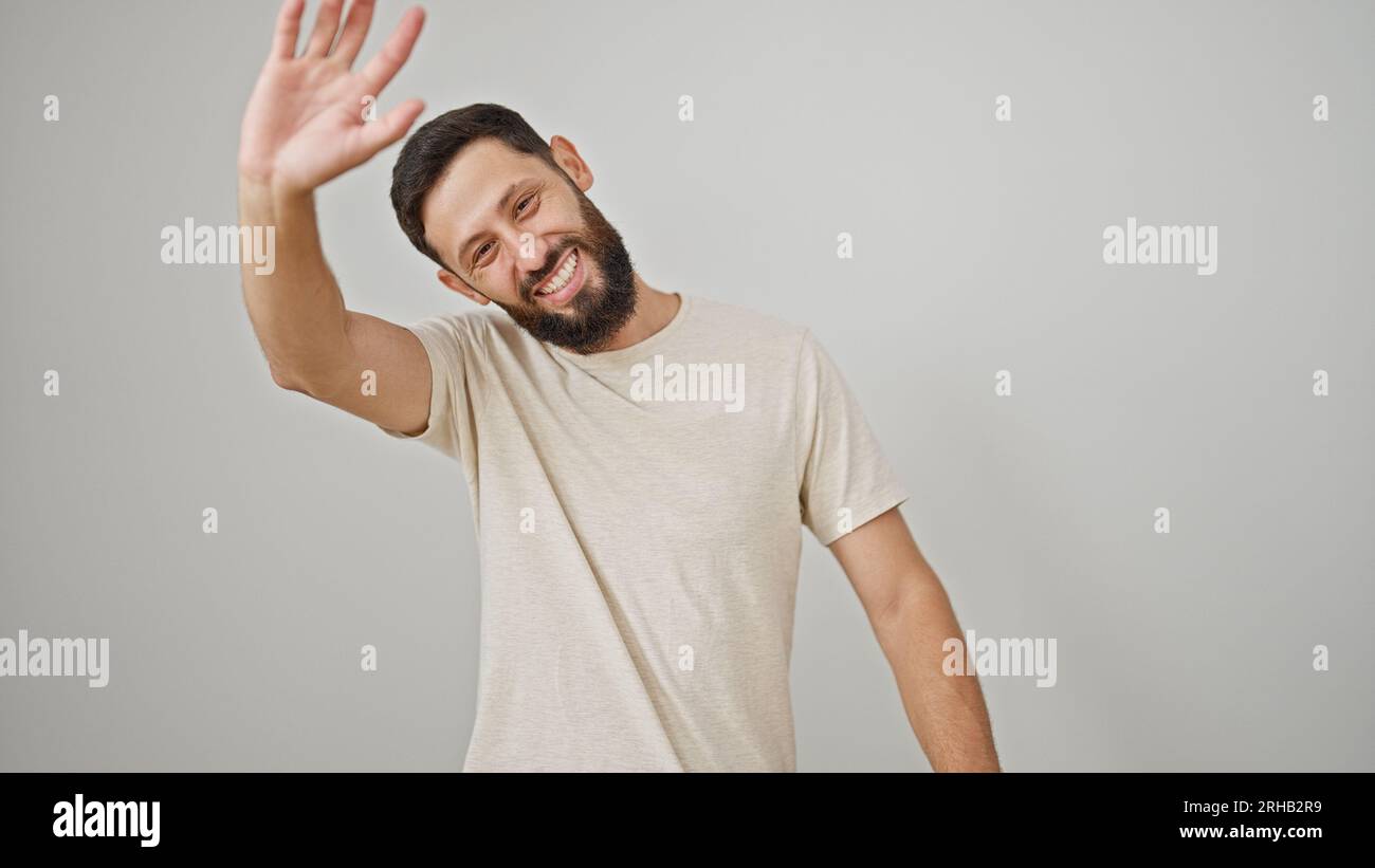 Young hispanic man smiling confident saying hello with hand over ...