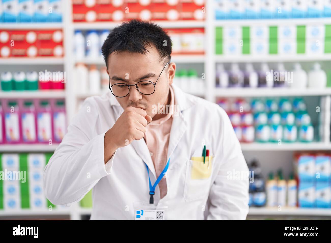 Chinese young man working at pharmacy drugstore feeling unwell and ...