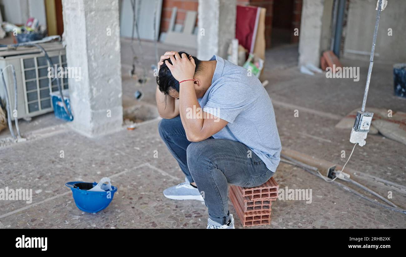architect stressed sitting on floor at construction site Stock Photo ...