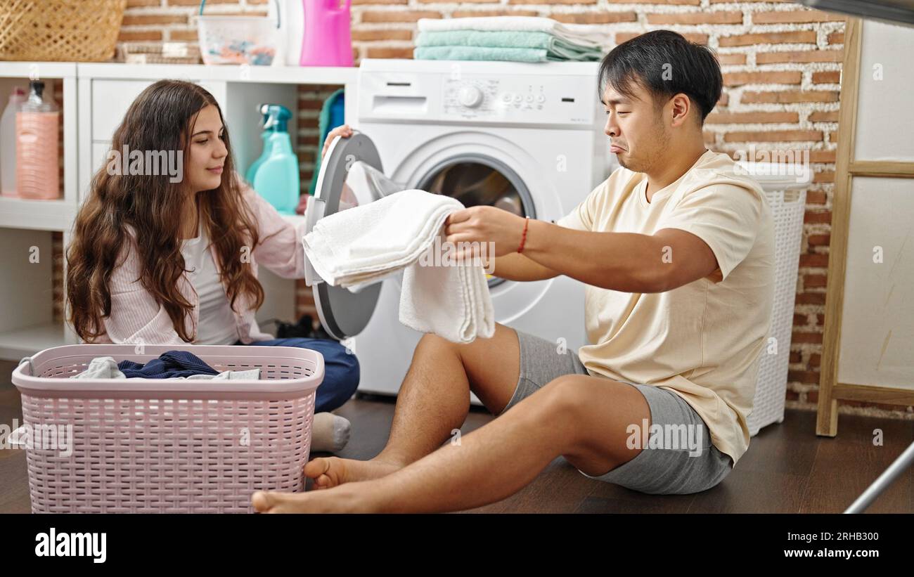 Man and woman couple washing clothes at laundry room Stock Photo - Alamy