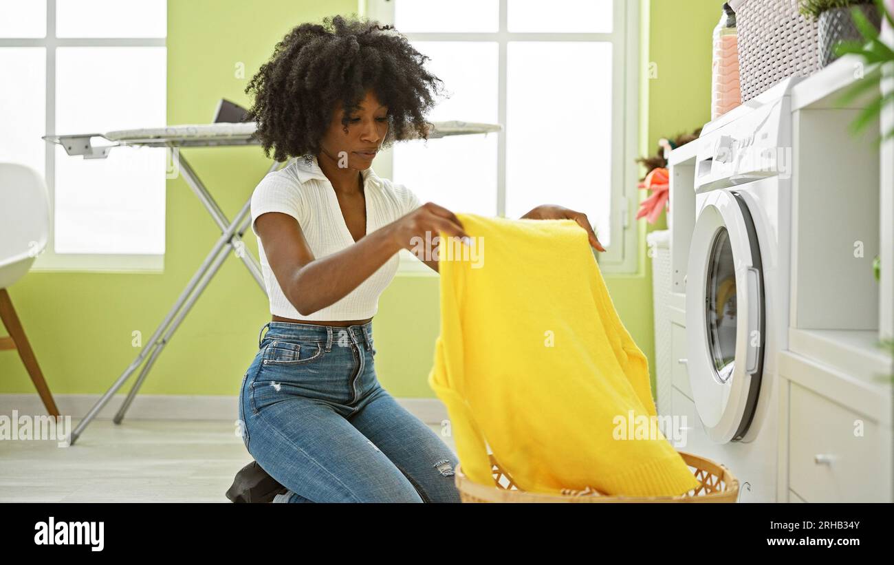 African american woman washing clothes at laundry room Stock Photo - Alamy