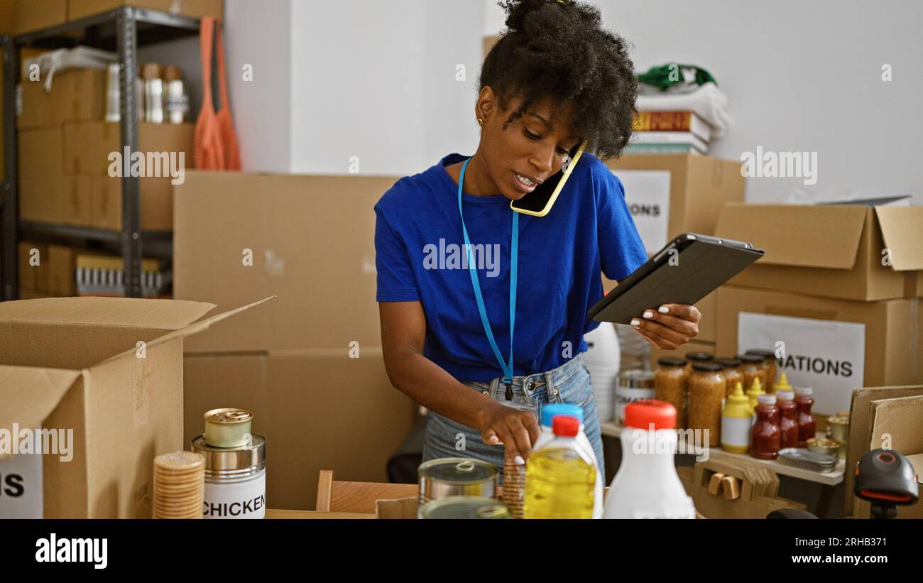 African american woman volunteer talking on smartphone using touchpad ...