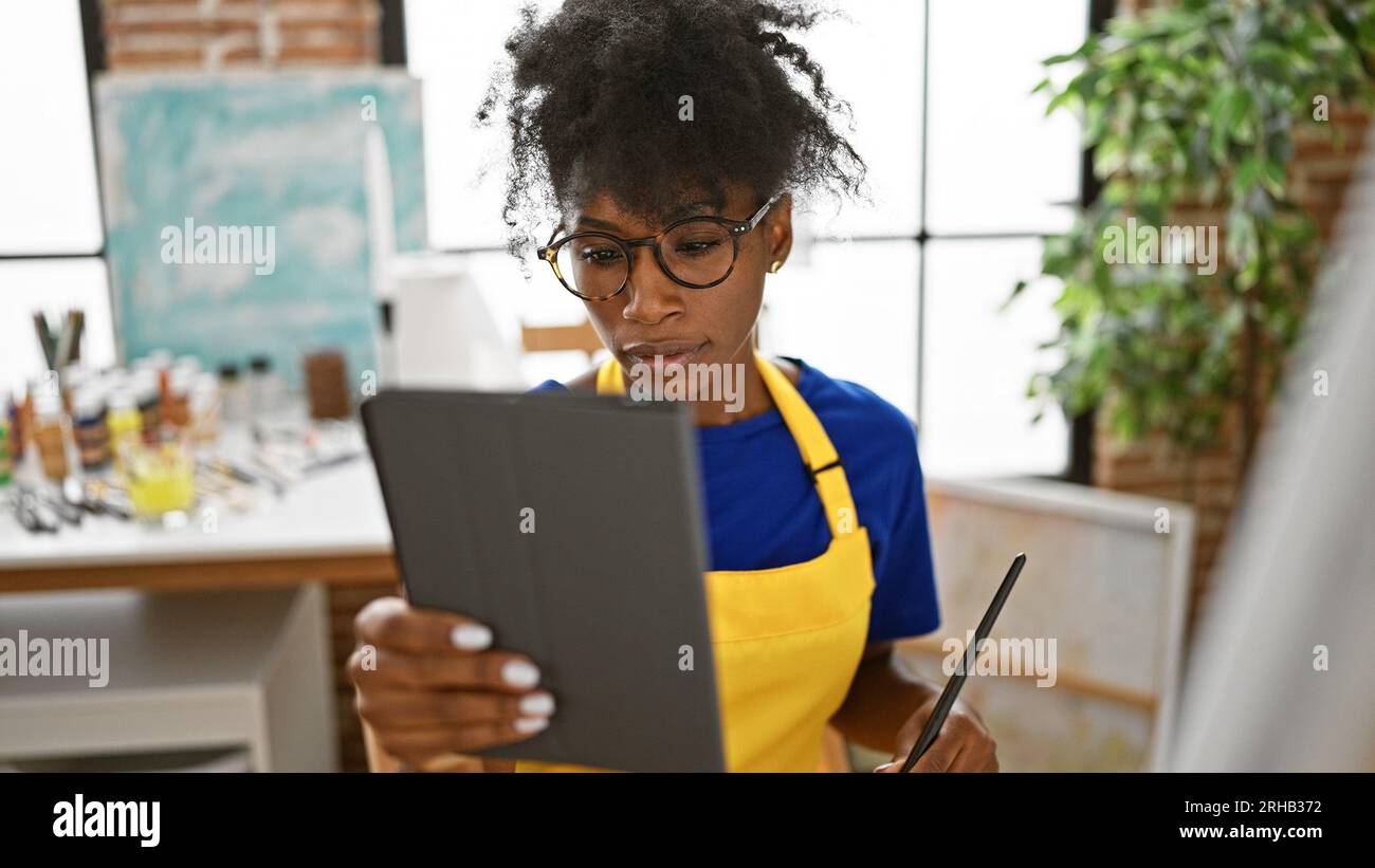African american woman artist looking touchpad drawing at art studio ...