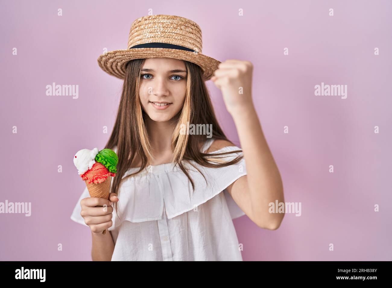 Teenager girl holding ice cream angry and mad raising fist frustrated ...