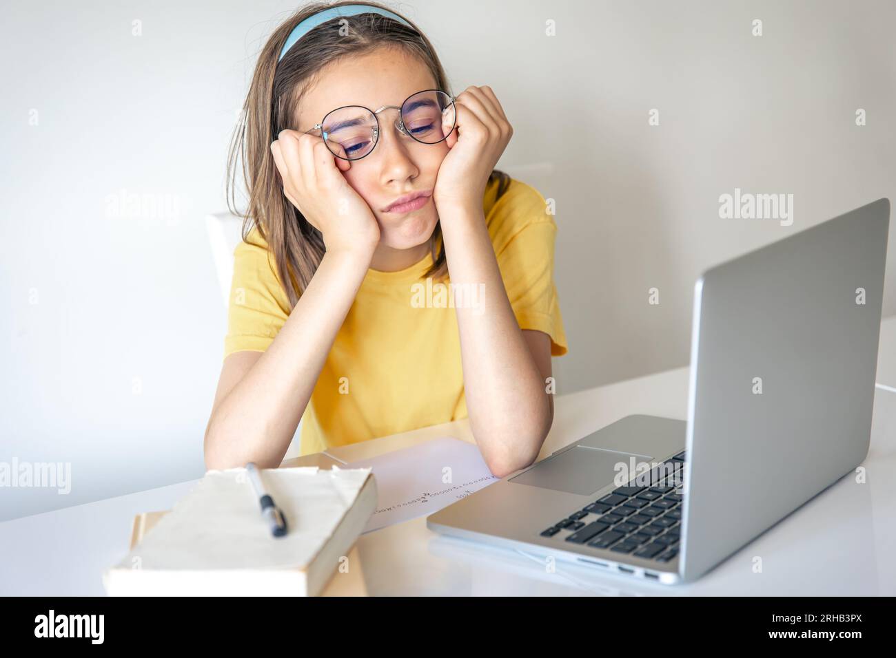 Exhausted schooler girl suffering from doing homework, tired from ...