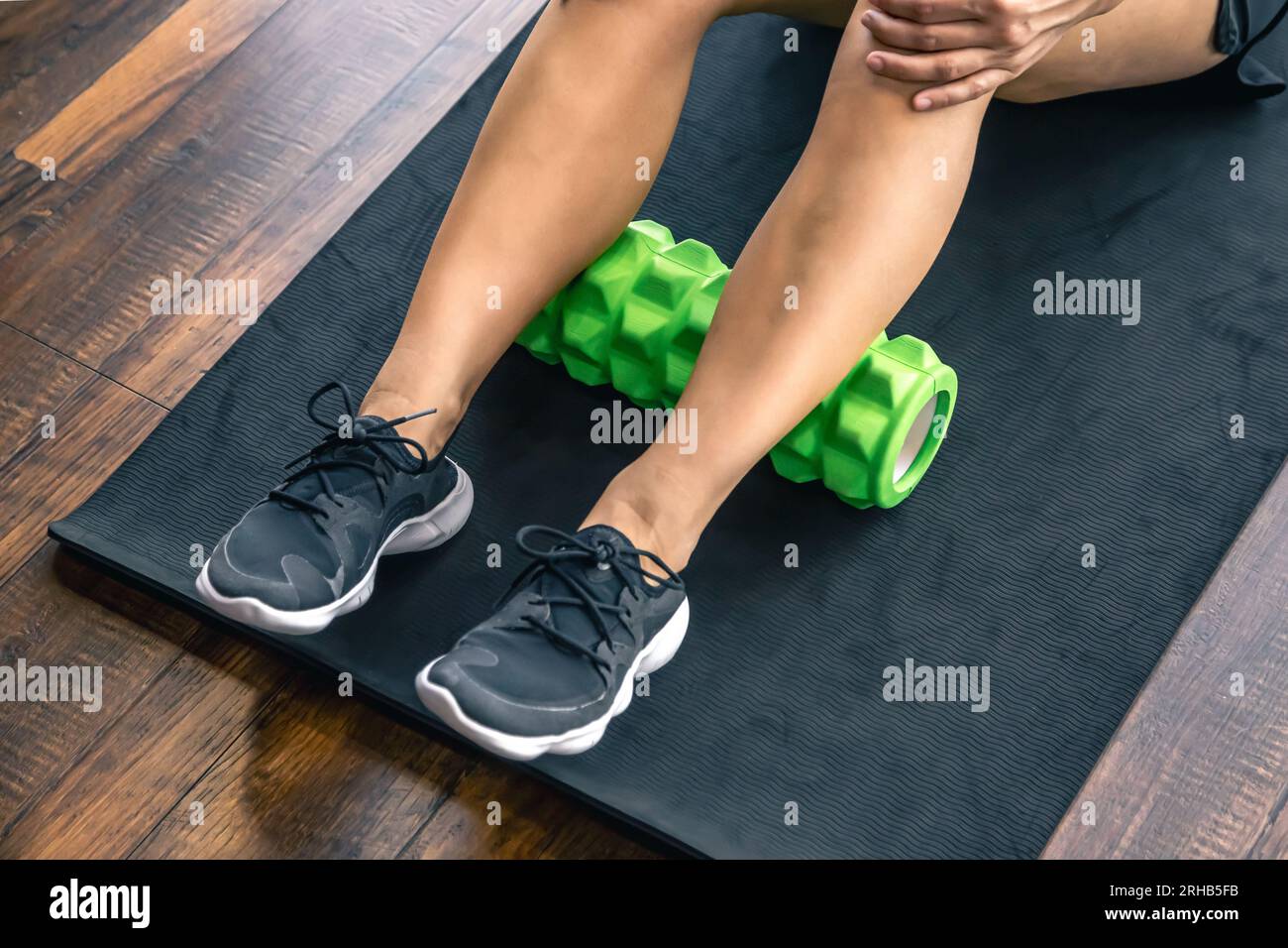 Sport woman using foam roller for muscle and fascia stretching foot ...