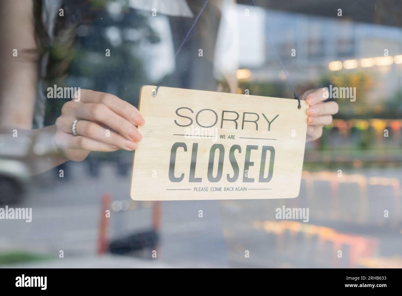 Female store owner turning close sign board of start up coffee shop ...