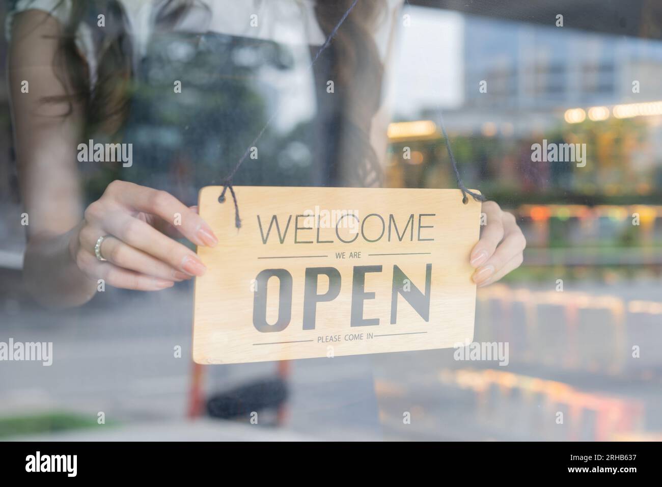 Female store owner turning open sign board of start up coffee shop cafe ...