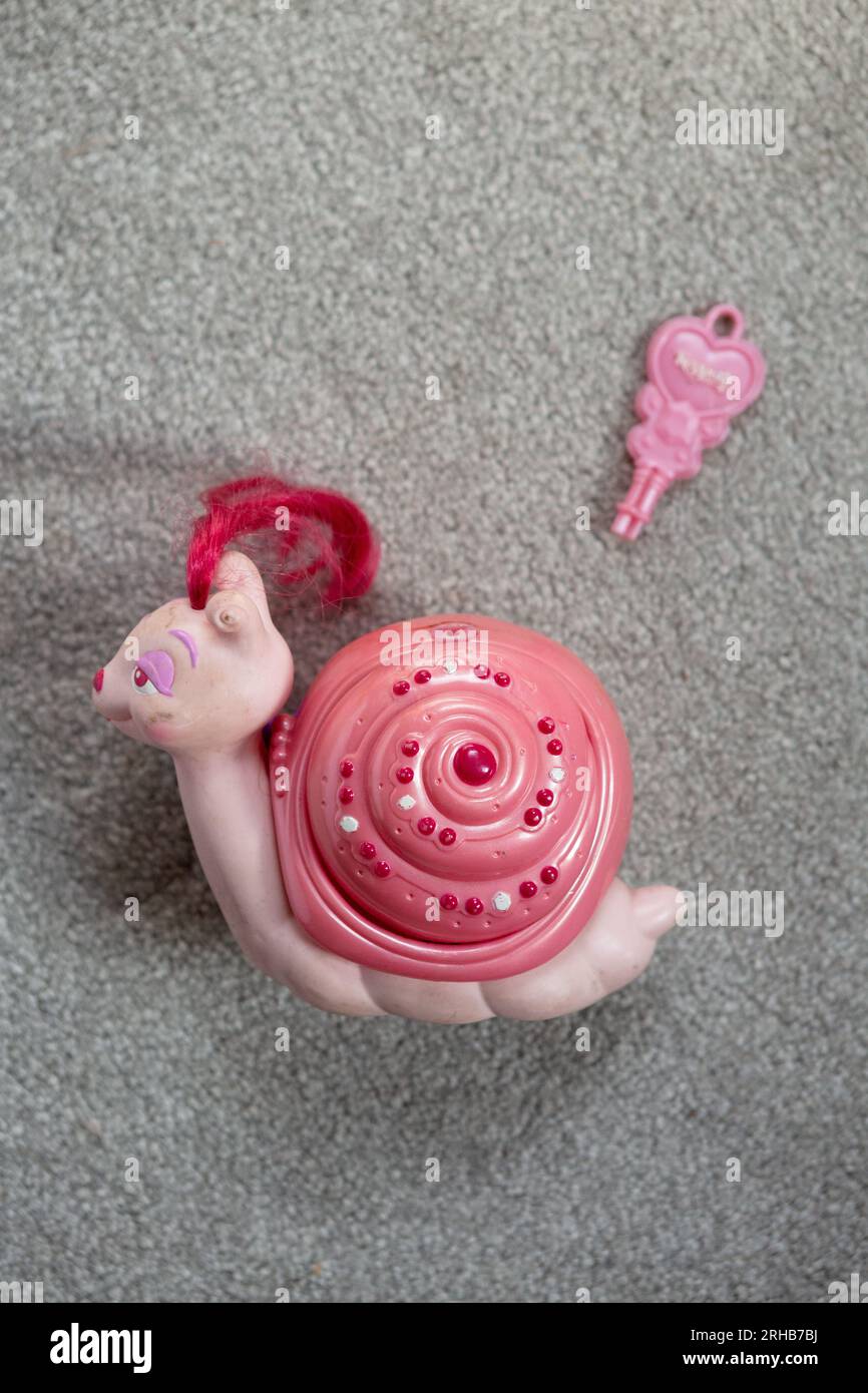 Pink plastic Keypers toy from the 1980s or 1990s, on a grey carpet ...