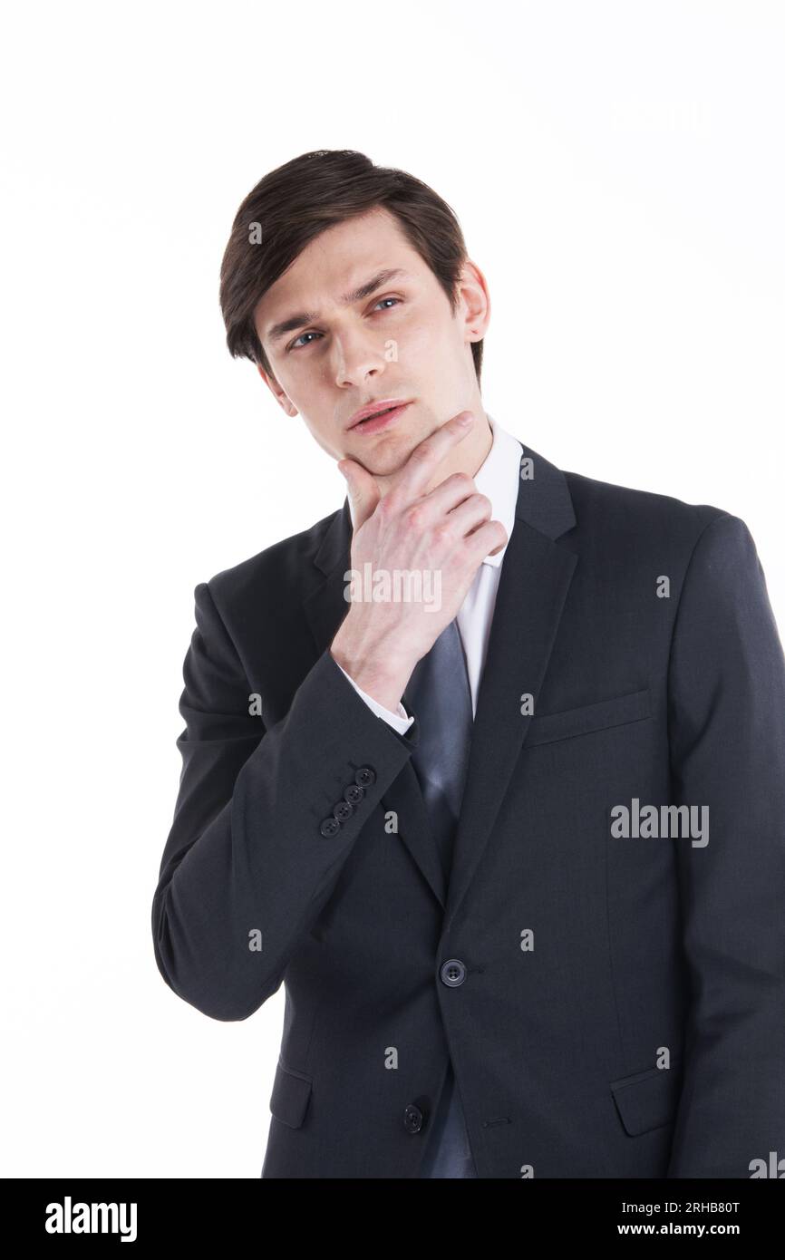 Portrait young business man holding hand in his chin while looking ...