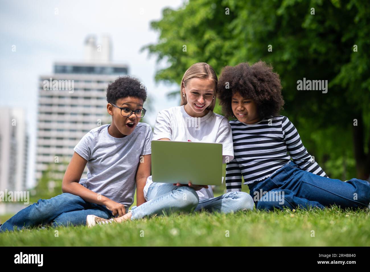 Blonde girl helping teens with their project work Stock Photo - Alamy