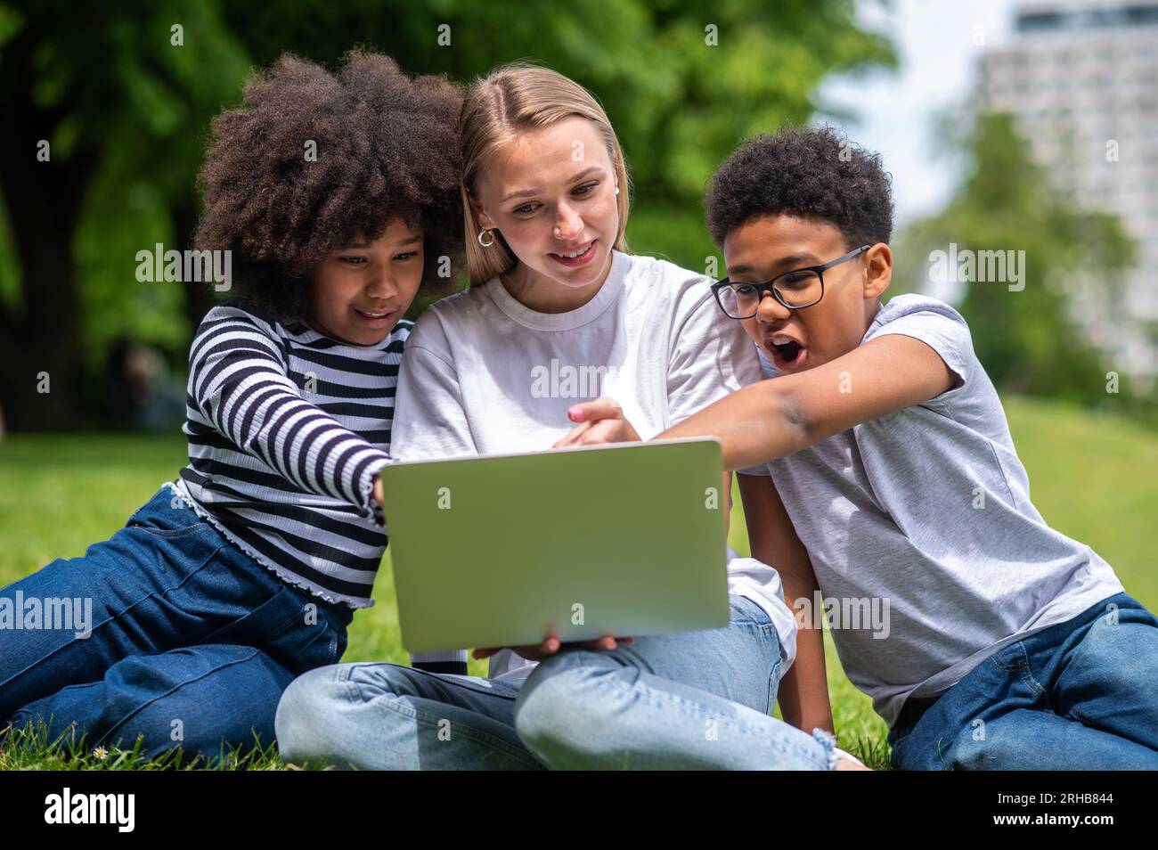 Blonde girl helping teens with their project work Stock Photo - Alamy