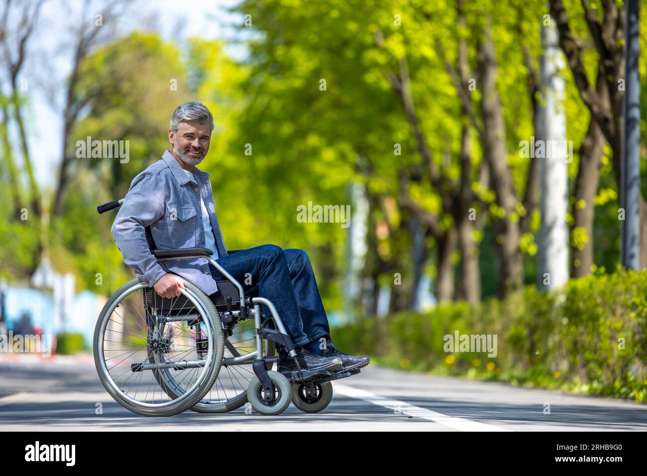 Handicapped man in wheelchair riding on street road, outdoor leisure ...