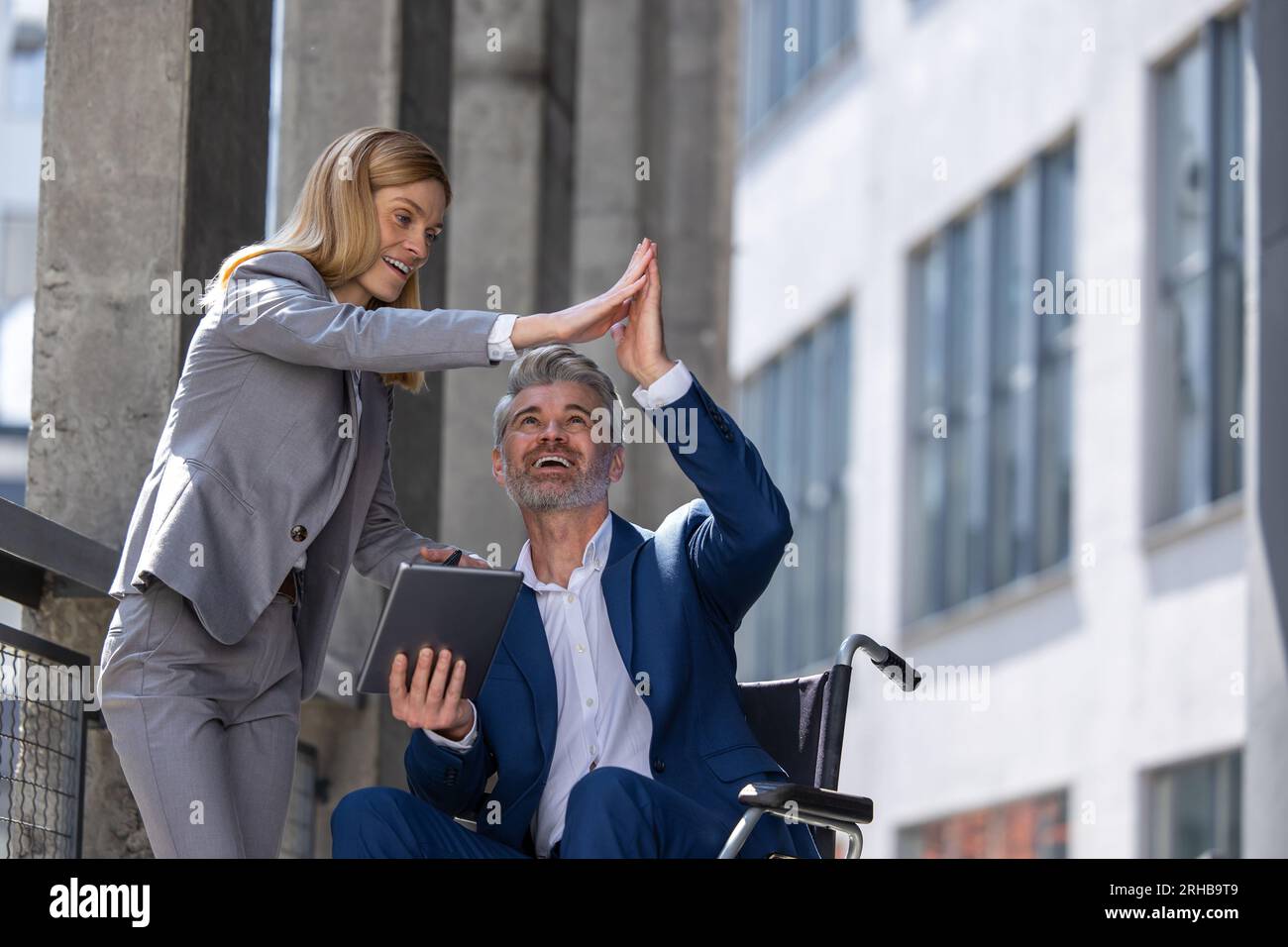 Two business persons giving high five, celebratingfinishing project ...