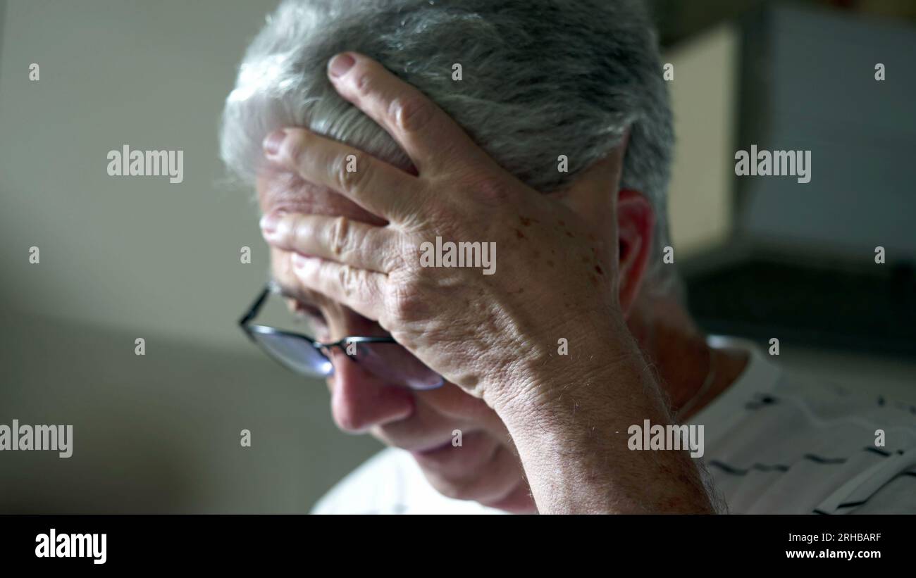 Preoccupied senior man feeling nervous reading content. Candid close-up ...