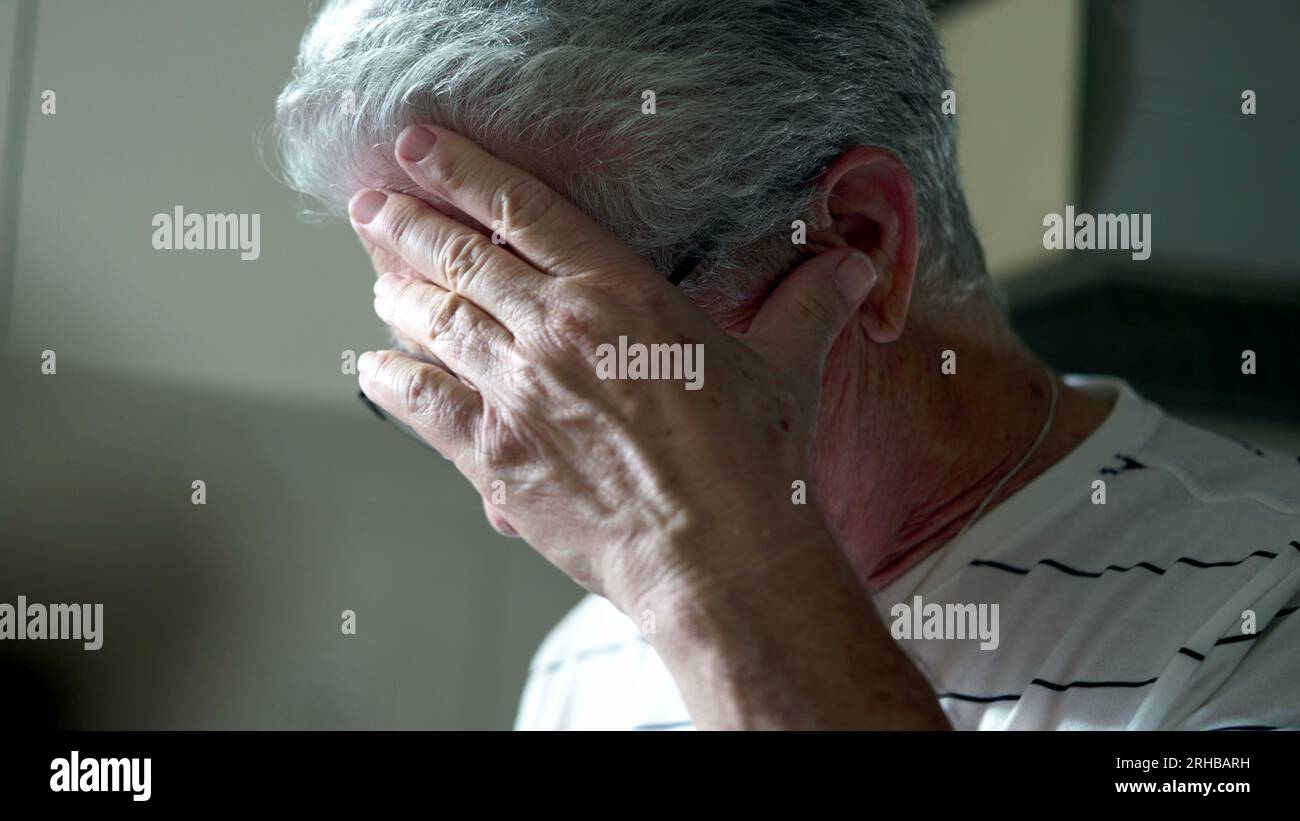 Preoccupied senior man feeling nervous reading content. Candid close-up ...