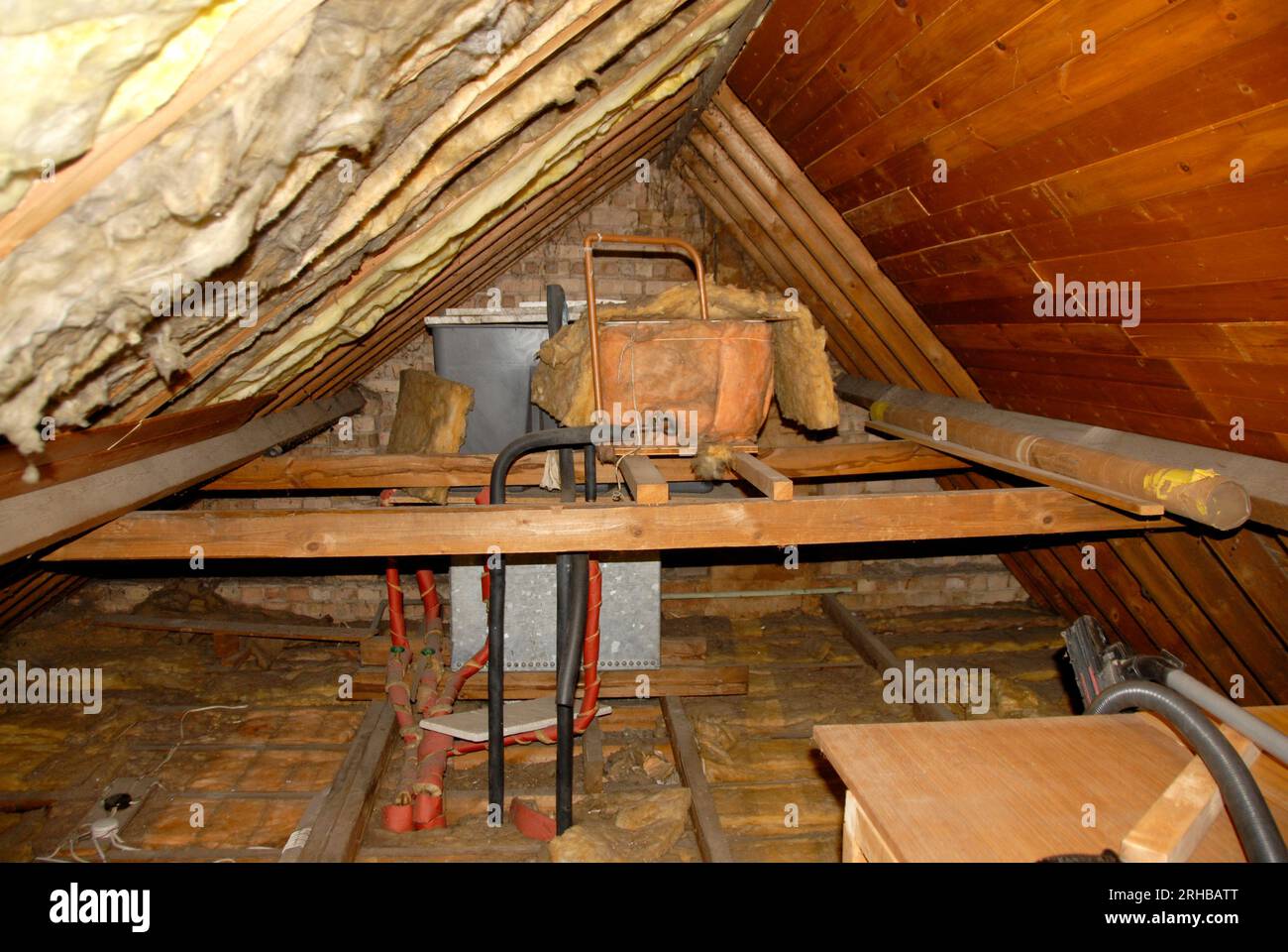 Interior of domestic loft with insulation and cold water tank and ...
