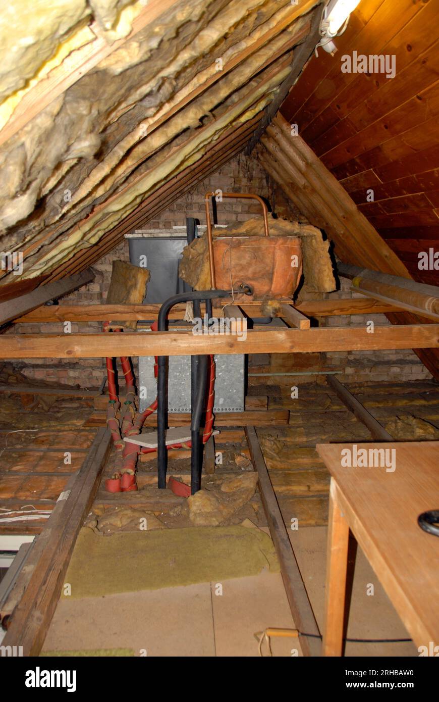 Interior of domestic loft with insulation and cold water tank and ...