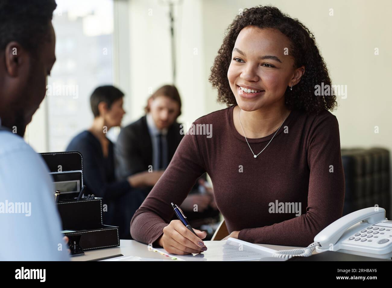 Portrait of smiling black woman working with client at legal firm Stock ...