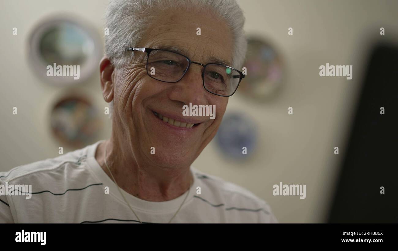 Senior man in front of computer screen, using modern technology. Gray ...