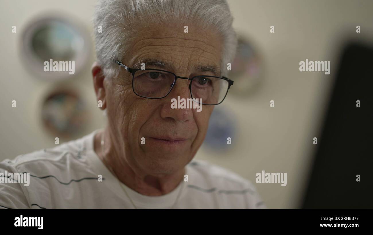 Senior man in front of computer screen, using modern technology. Gray ...