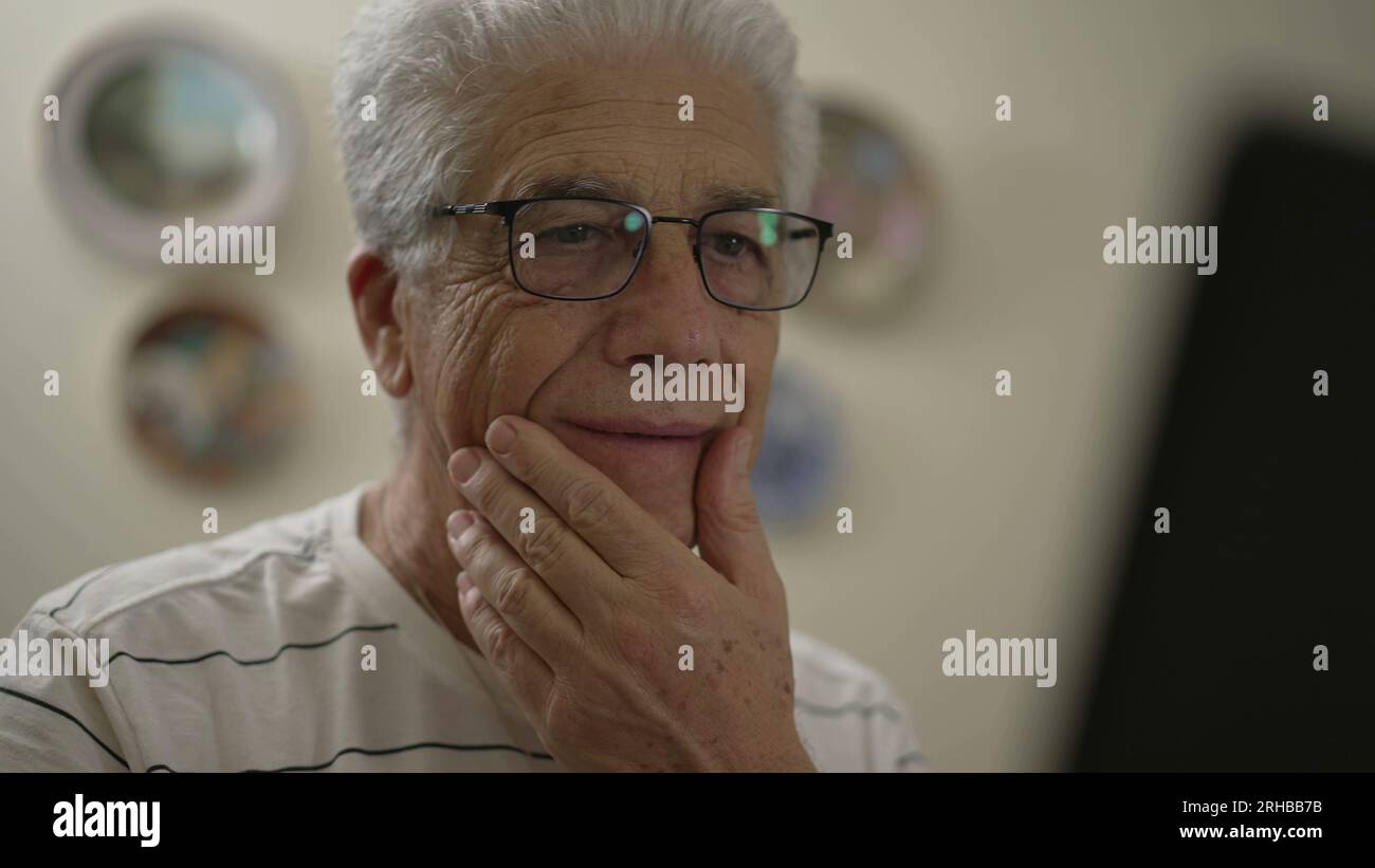 Senior man in front of computer screen, using modern technology. Gray ...
