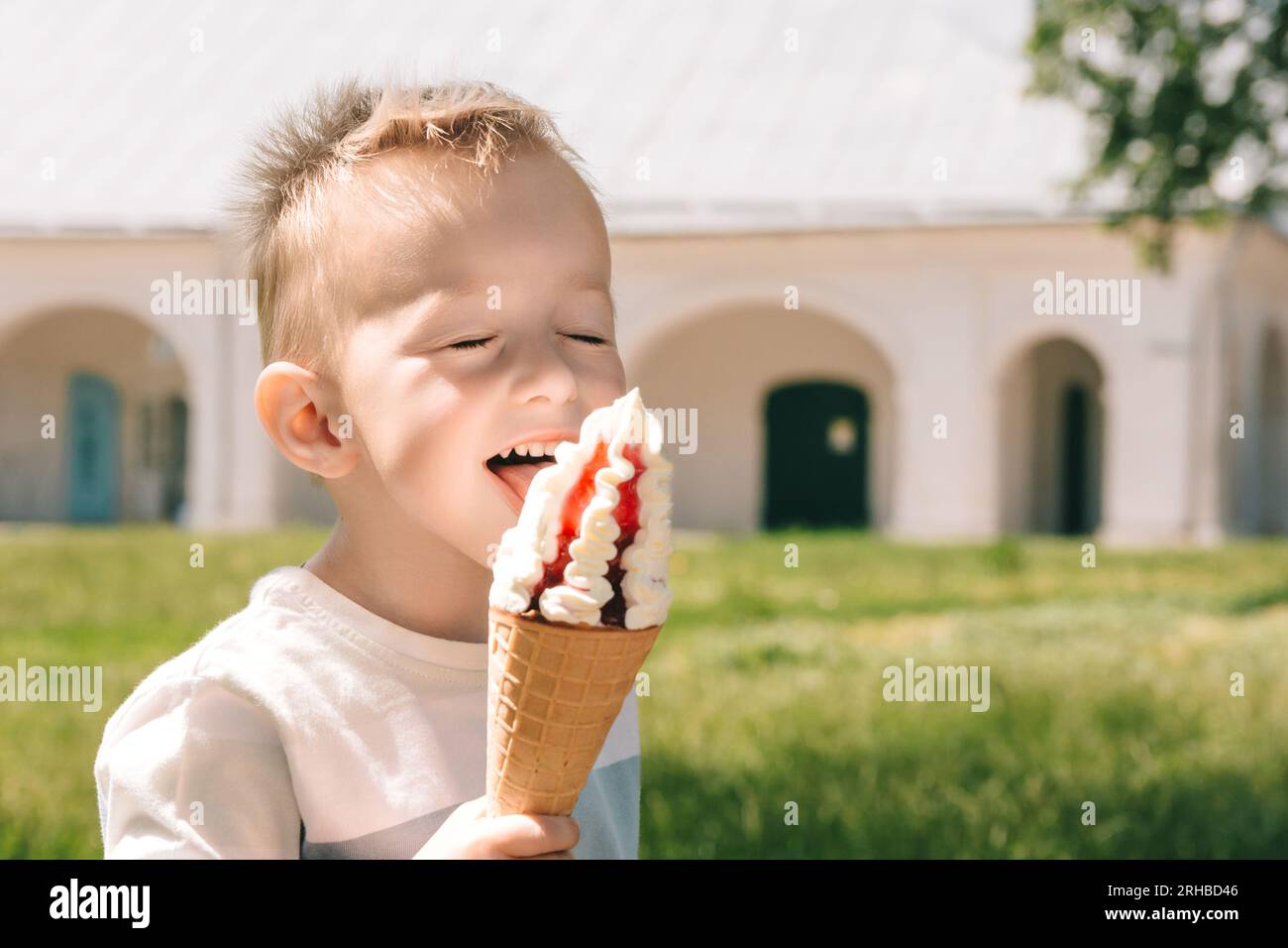 Portrait of a little boy. A baby eats a delicious ice cream cone. Happy ...