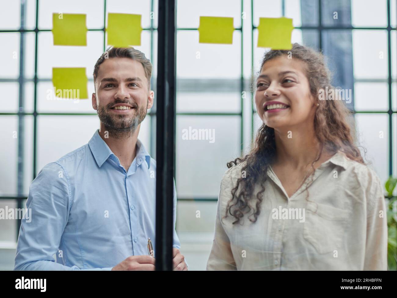 Business people talking in the hallway of the modern office building with employees working ...