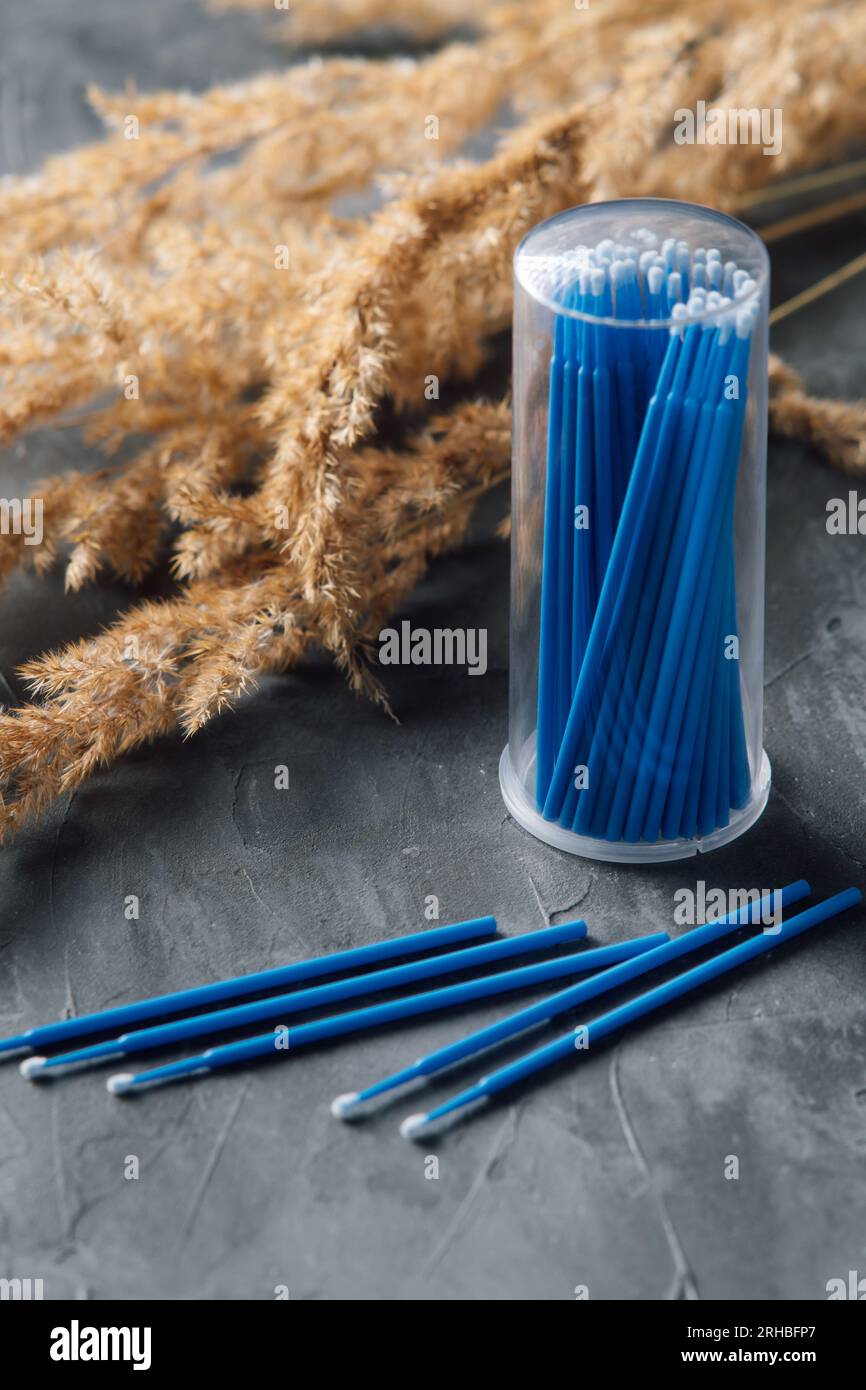 Professional microbrushes with blue stick lying in container and left ...
